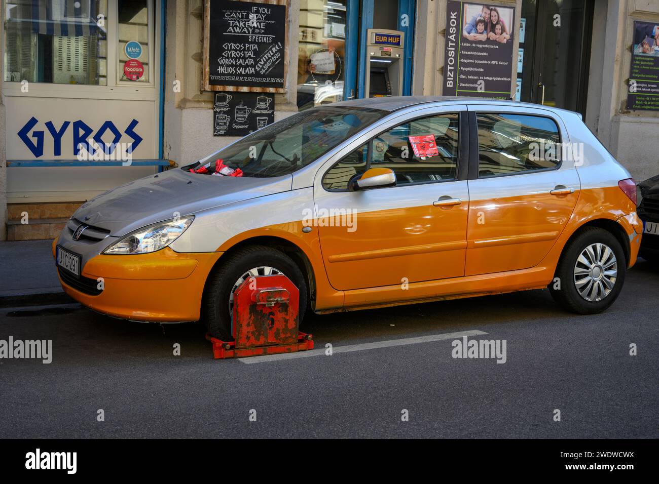 Car with a wheel clamp The red lock is placed on a wheel for improper ...