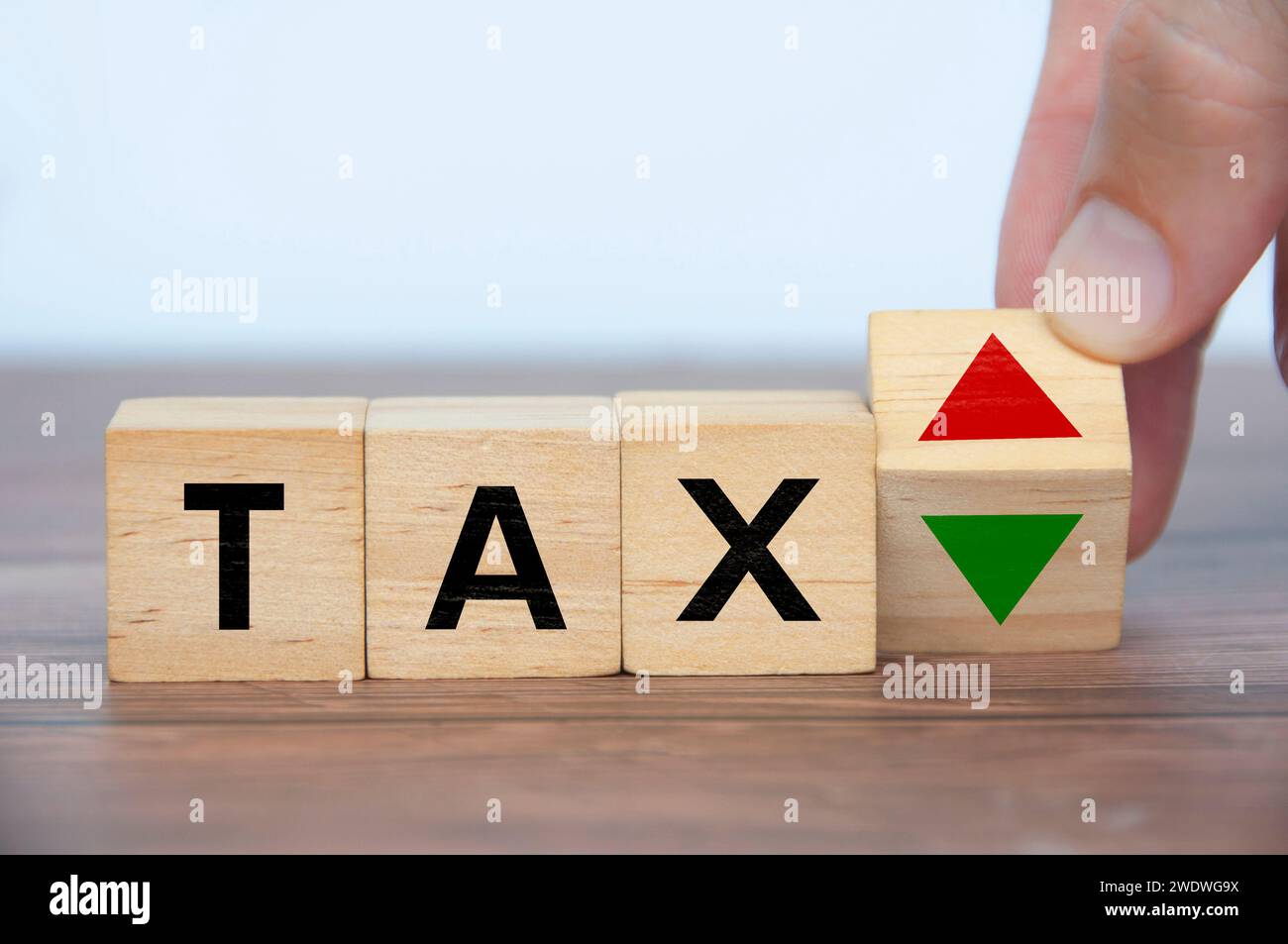 Hand turning blank wooden cubes with word tax. Taxation time concept ...