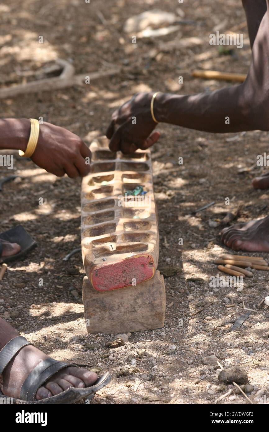 Datooga men play Mancala. Photographed in Tanzania. Mancala is one of ...