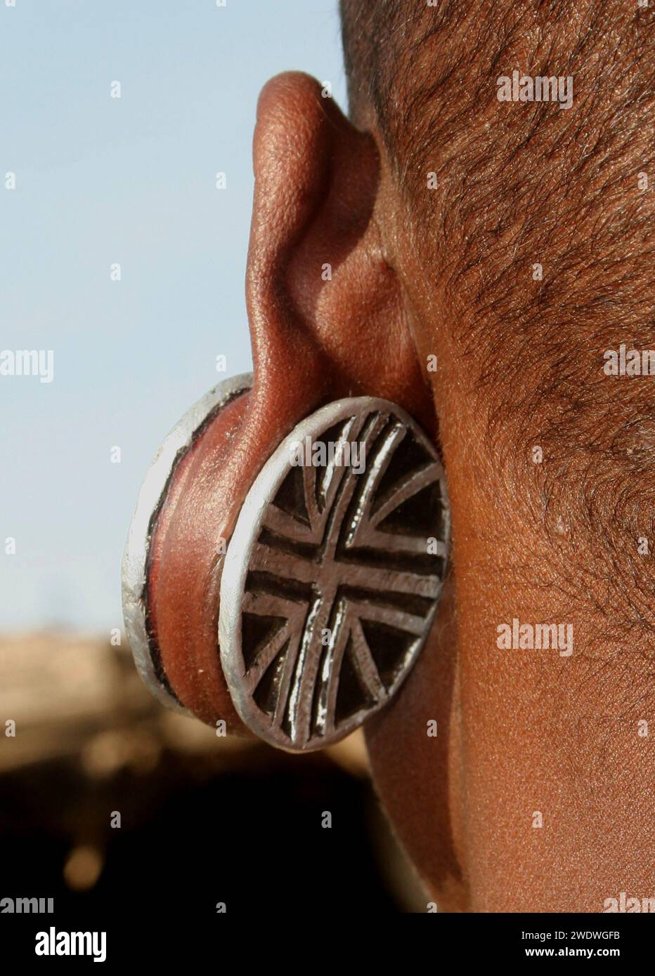 Female member of the Datoga tribe with shaven head in traditional dress ...