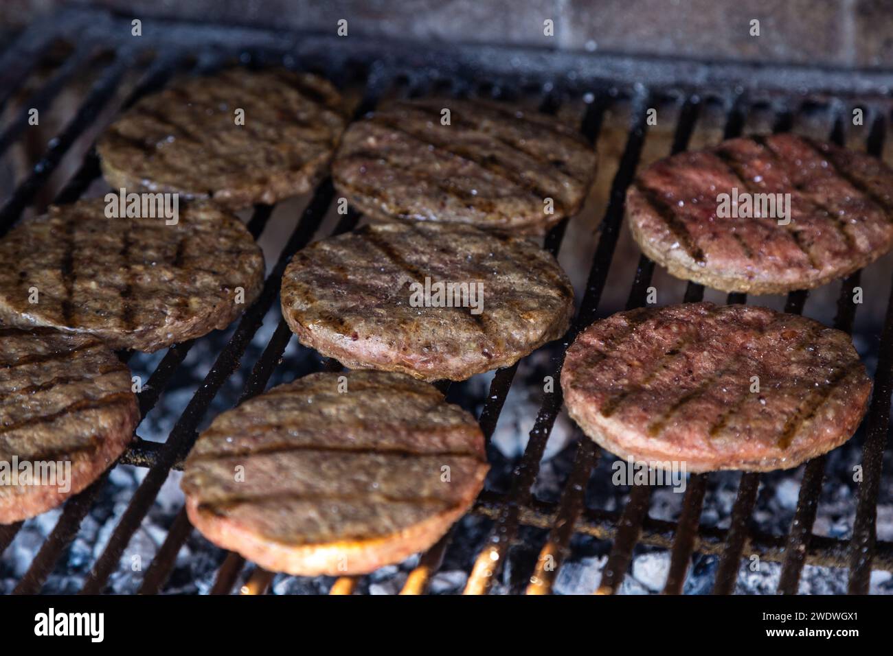 Real Burgers grilling on the barbecue Stock Photo - Alamy
