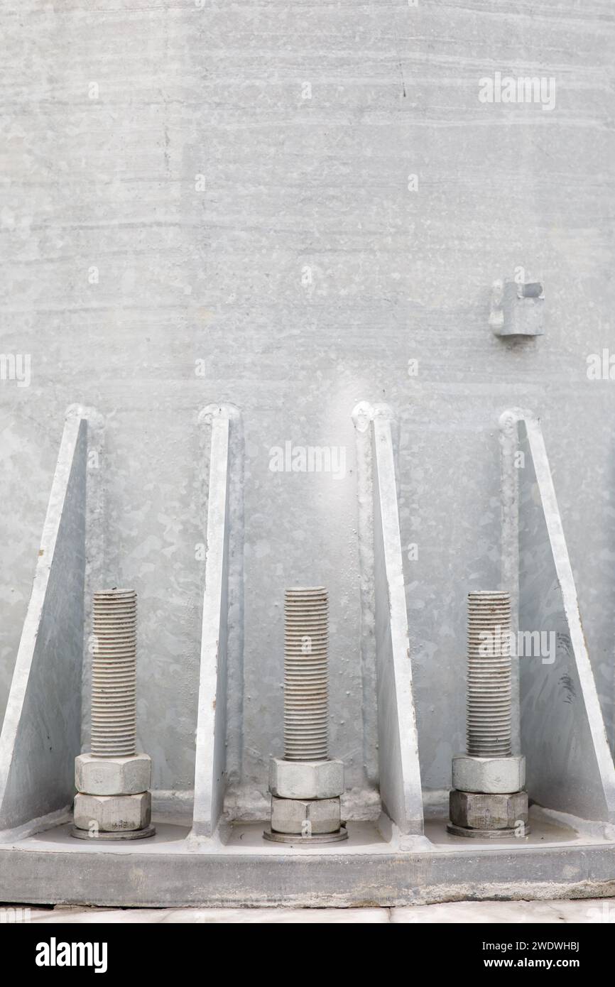 Bolts and nuts on a steel plate. Several pairs of silver bolts are ...