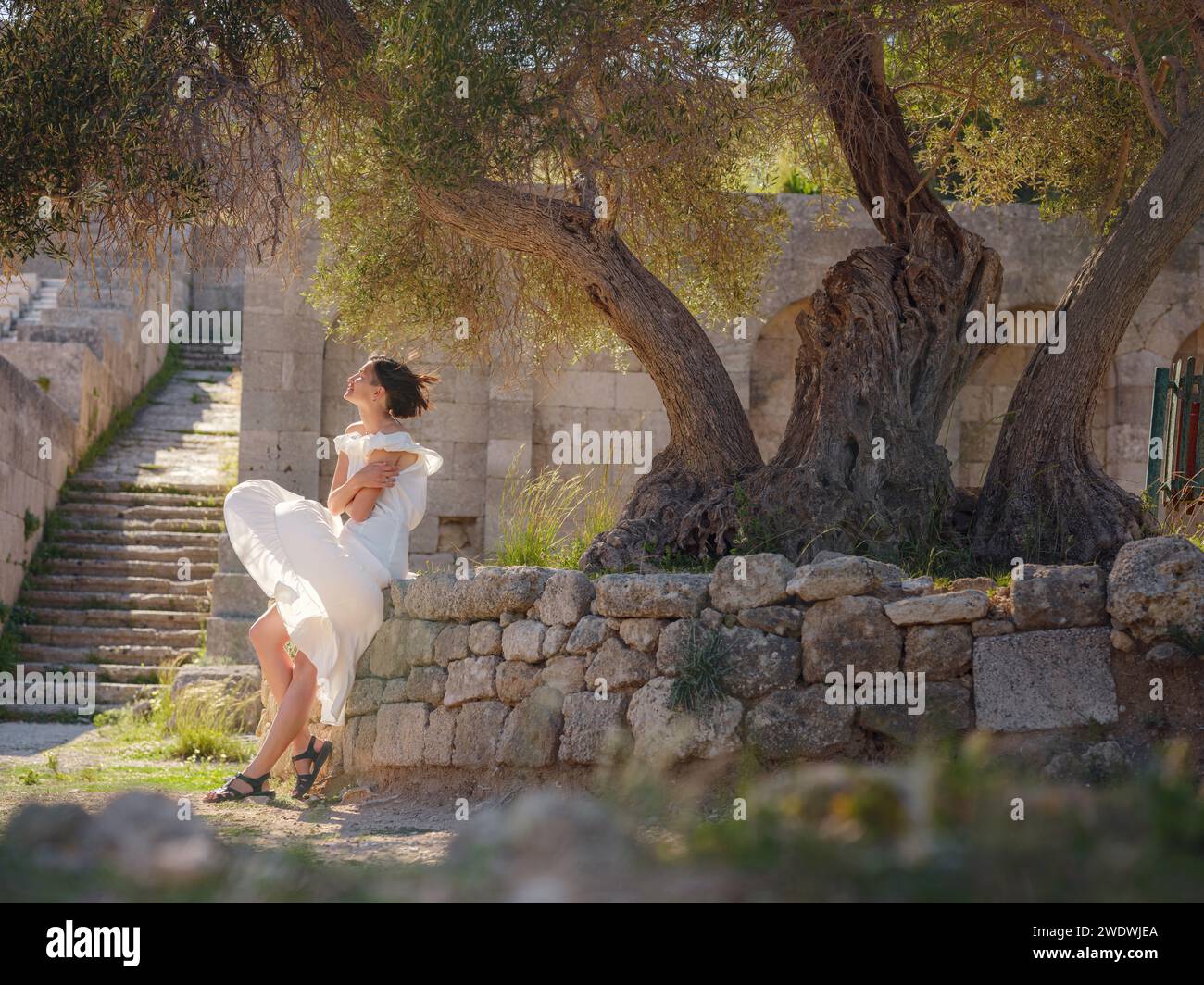 Beautiful Asian young woman in white dress outdoor. Acropolis of Rhodes ...