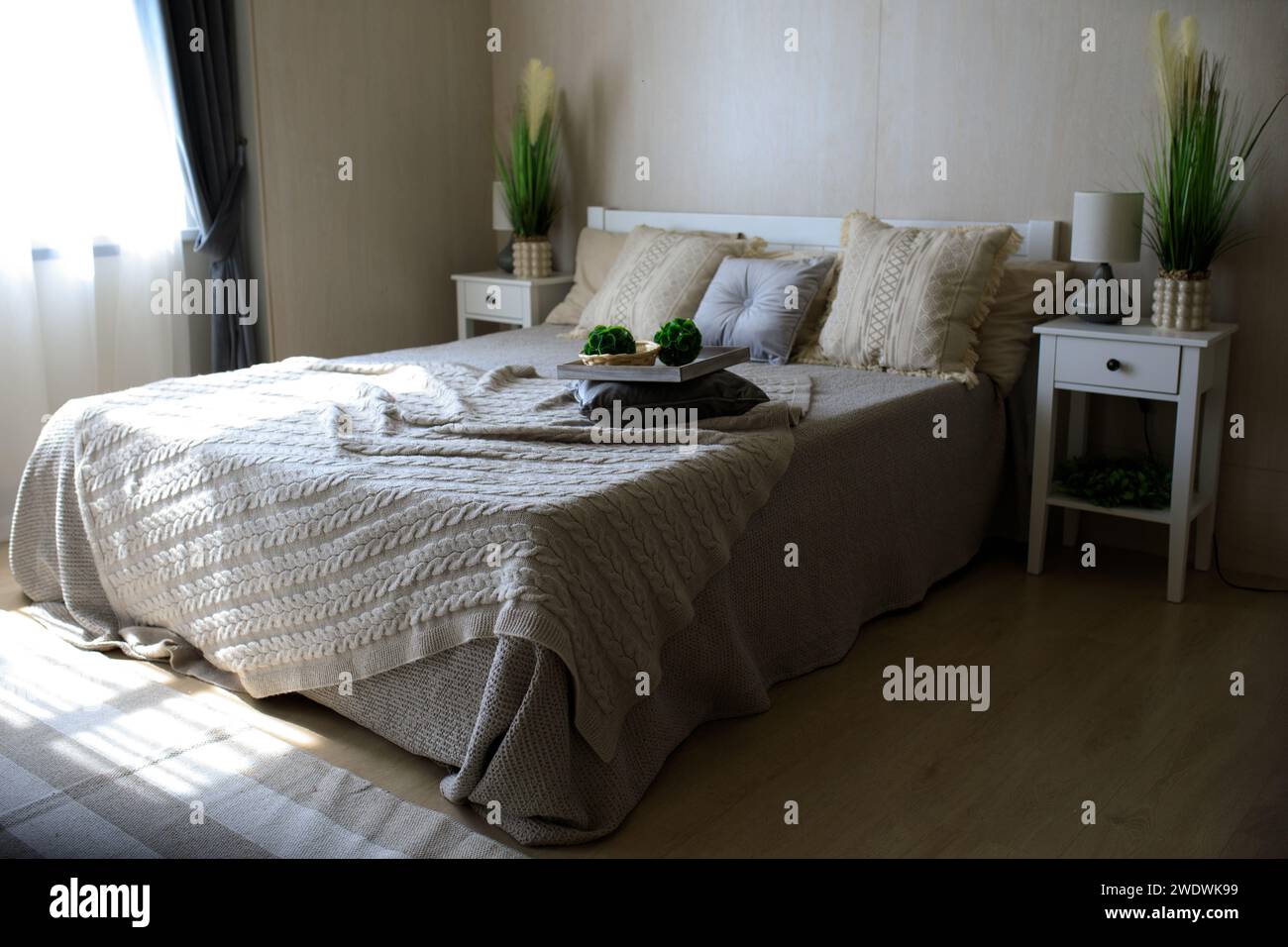 the bed is made beautifully, the bedroom is in gentle colors. High ...