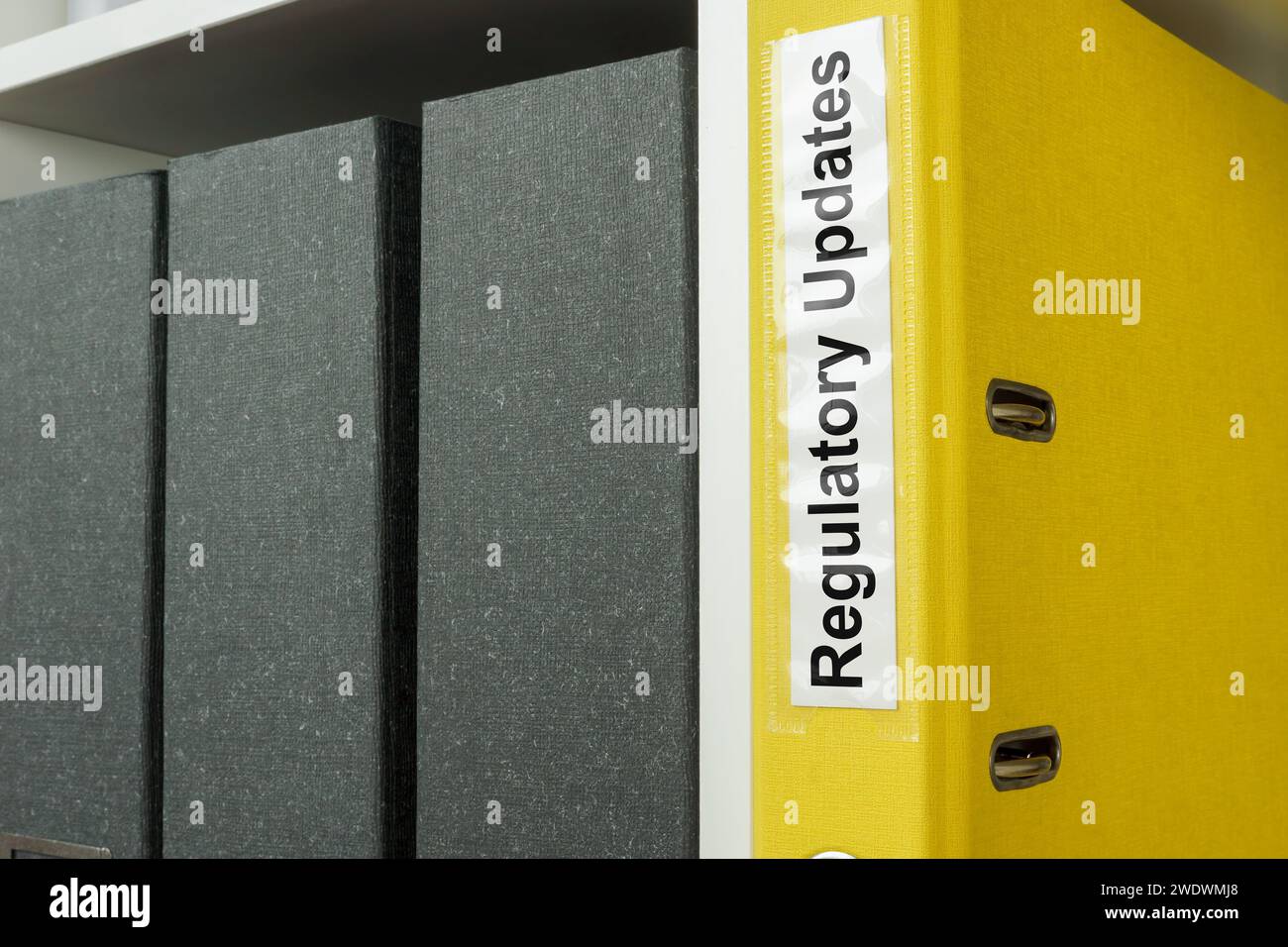 Folder with label regulatory updates on the shelf Stock Photo - Alamy