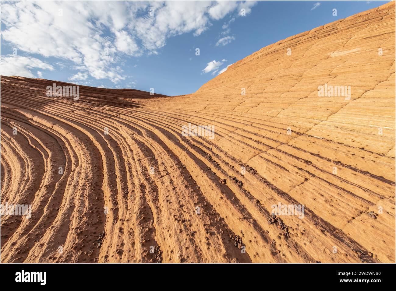 Rock lines on yellow rock lead into the picture towards the blue sky ...