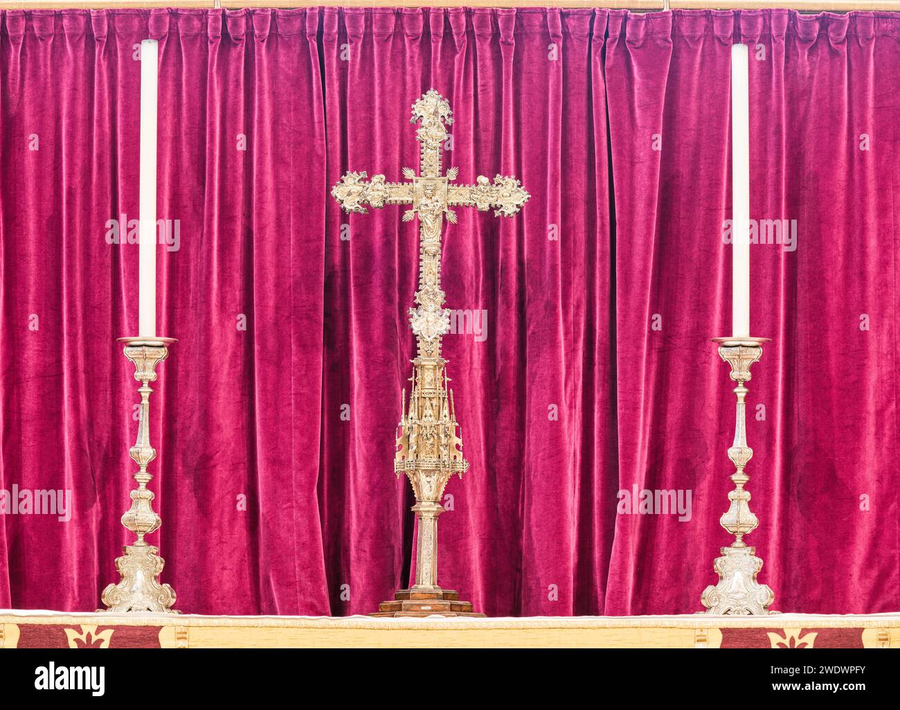 Crucifix and candles on the main altar in the chancel of the medieval ...