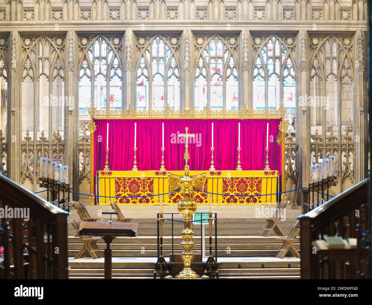 Crucifix and candles on the main altar in the chancel of the medieval ...