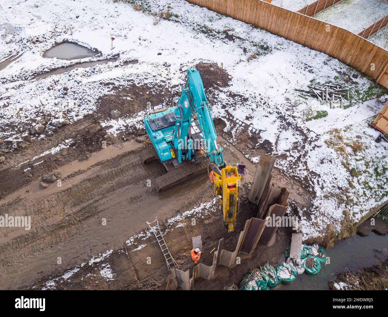 Aerial photo of a sheet pile hammer fitted to an excavator vibrating ...