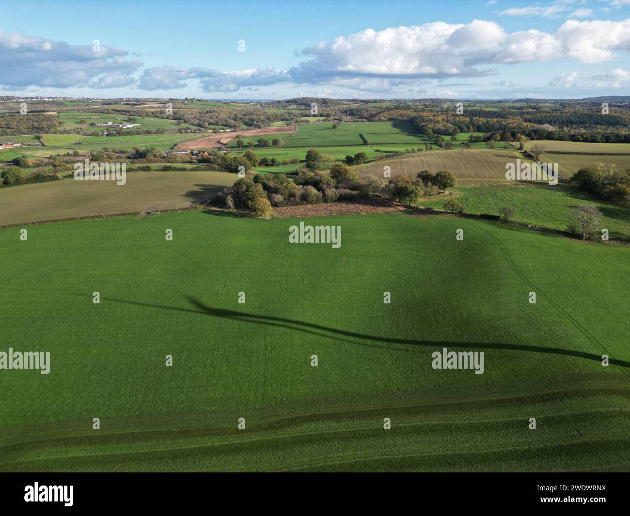 A Aerial drone shot of onshore wind turbine in field on farm land ...