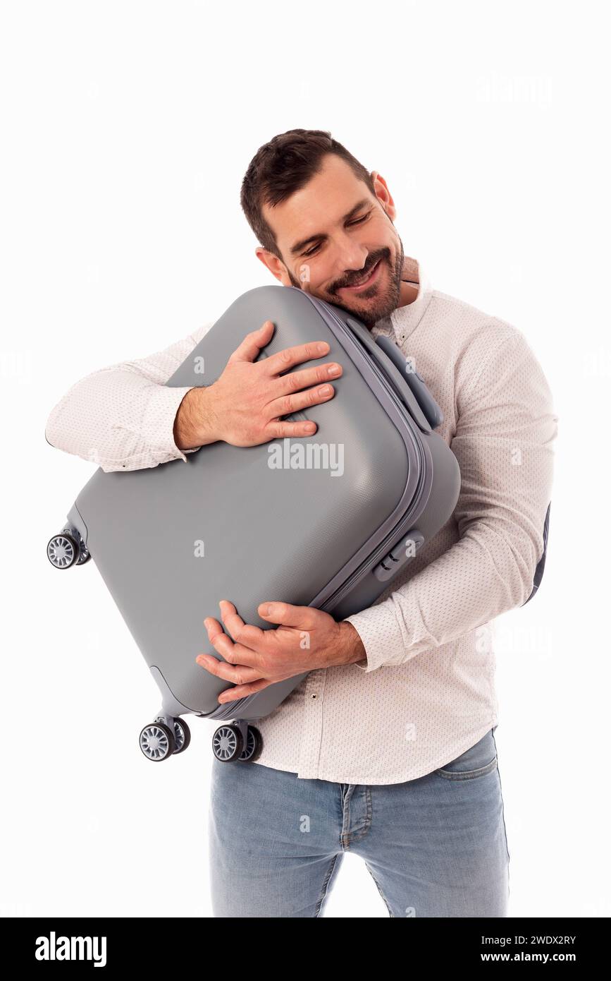 Bearded man hugging his travel suitcase. Traveling brings happiness ...