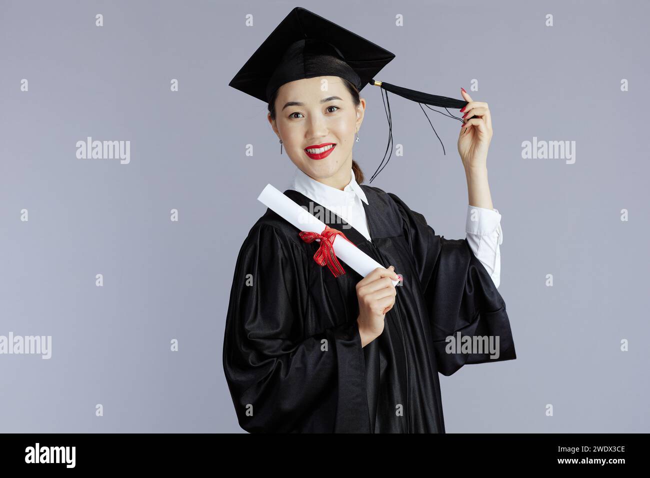 smiling modern graduate student asian woman with diploma throwing ...