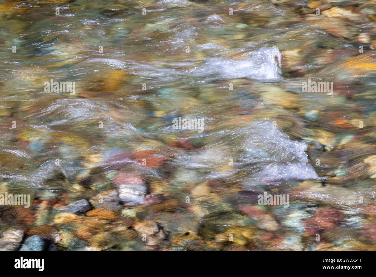Naturally colorful river rocks under water in Glacier National Park ...