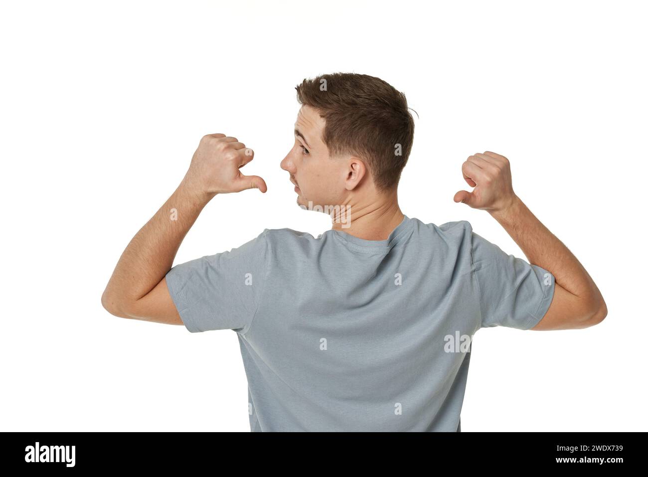 happy guy looking pointing to his back on white studio background Stock ...