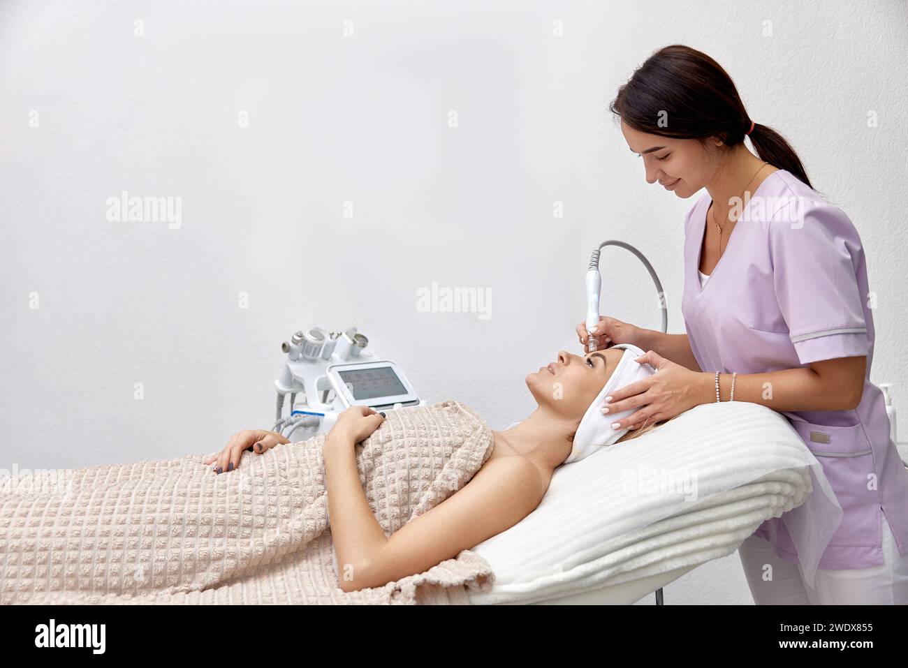 cosmetologist doing peeling procedure for female client in beauty salon ...