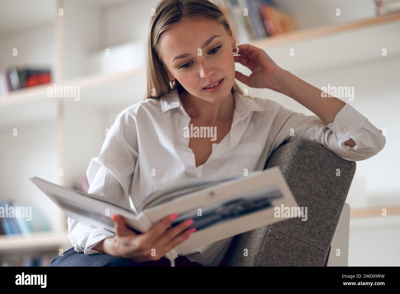 Woman resting at home reading book in modern home interior Stock Photo ...