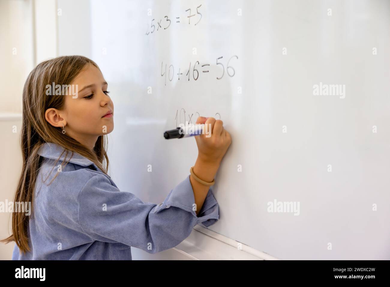 Little girl counting math equation on whiteboard in school Stock Photo ...