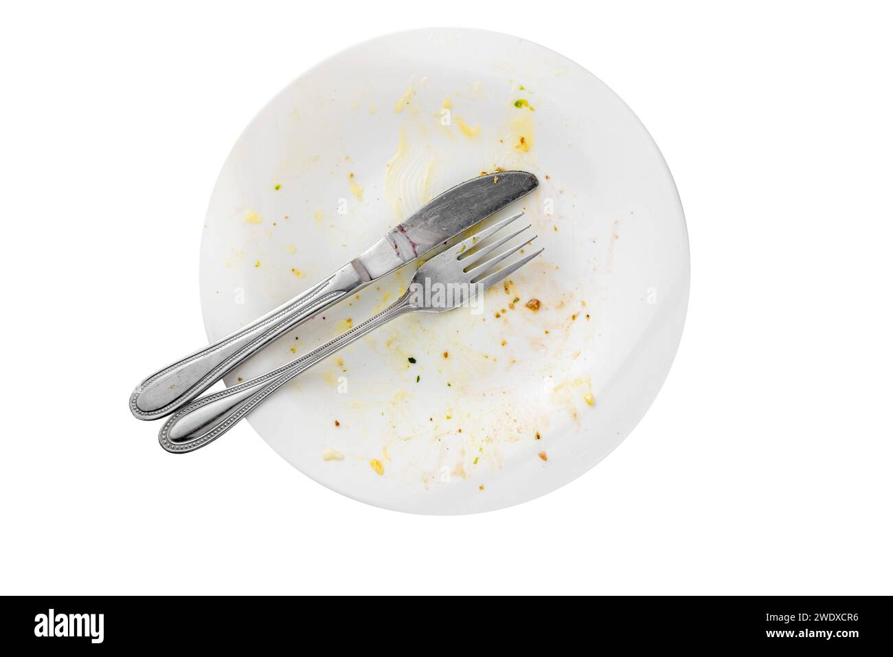 Empty dirty plate with leftovers, knife and fork isolated on white ...