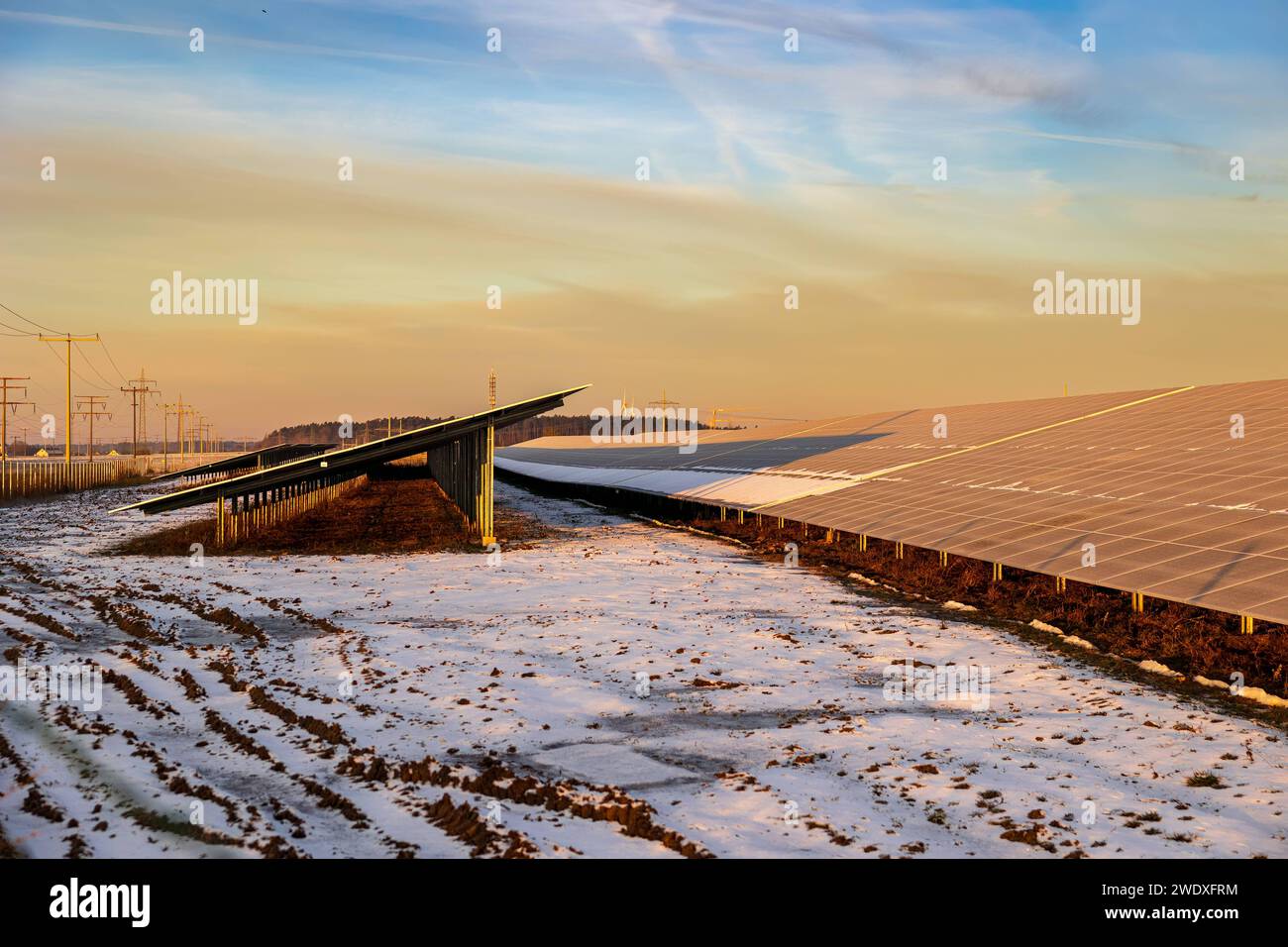Ein Solarpark mit vereisten und schneebedeckten Solarmodulen. Im Winter ...