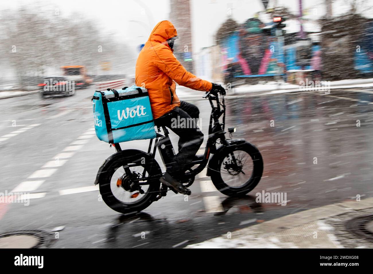 Ein Volt Fahrer mit Lieferando Jakett auf dem Fahrrad unterm Schneefall in Berlin am 16. Januar ...