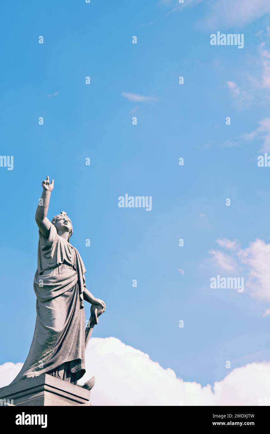 A cemetery statue pointing toward a blue sky Stock Photo - Alamy