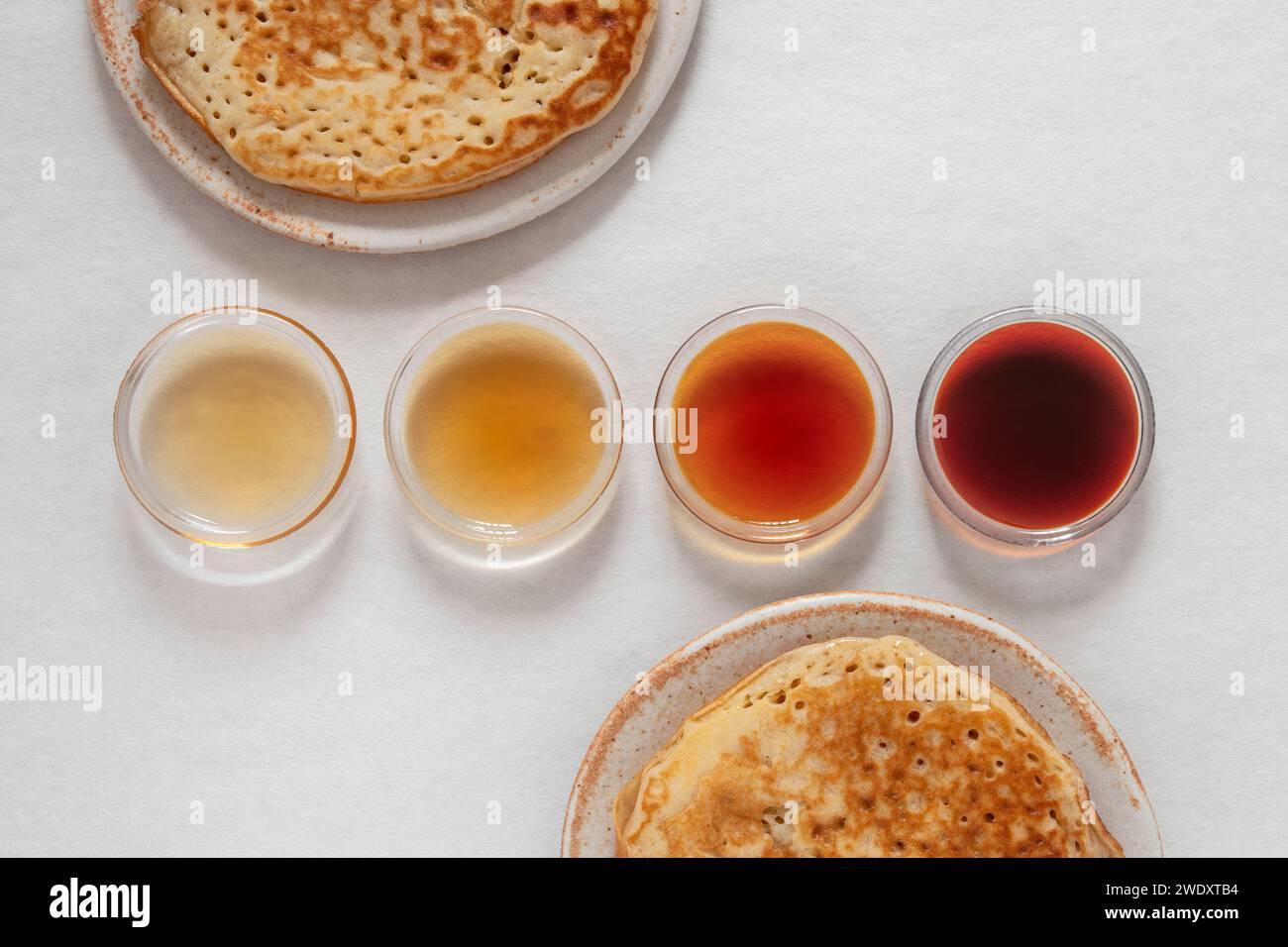 Different classes of maple syrups in different colours in glass bowls ...