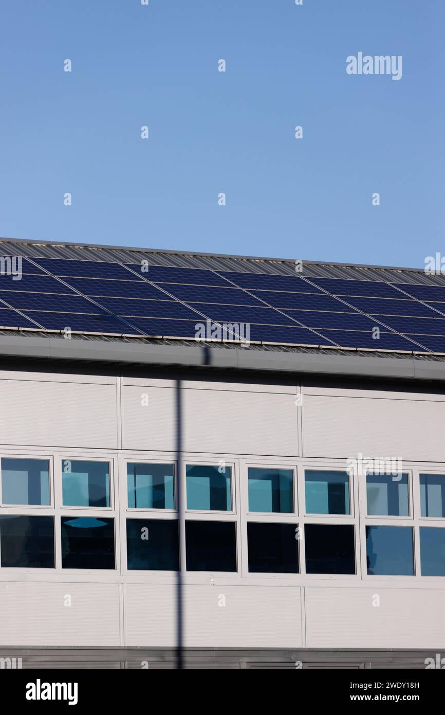 Modern commercial building exterior with grey cladding and photovoltaic ...