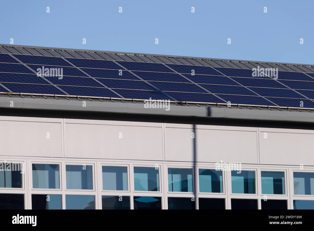 Modern commercial building exterior with grey cladding and photovoltaic ...