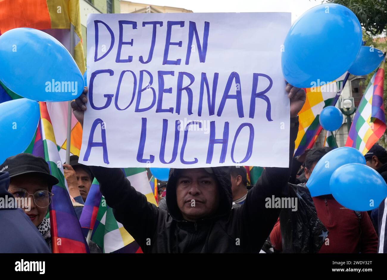 A supporter of Bolivian President Luis Arce holds a sign with a message ...
