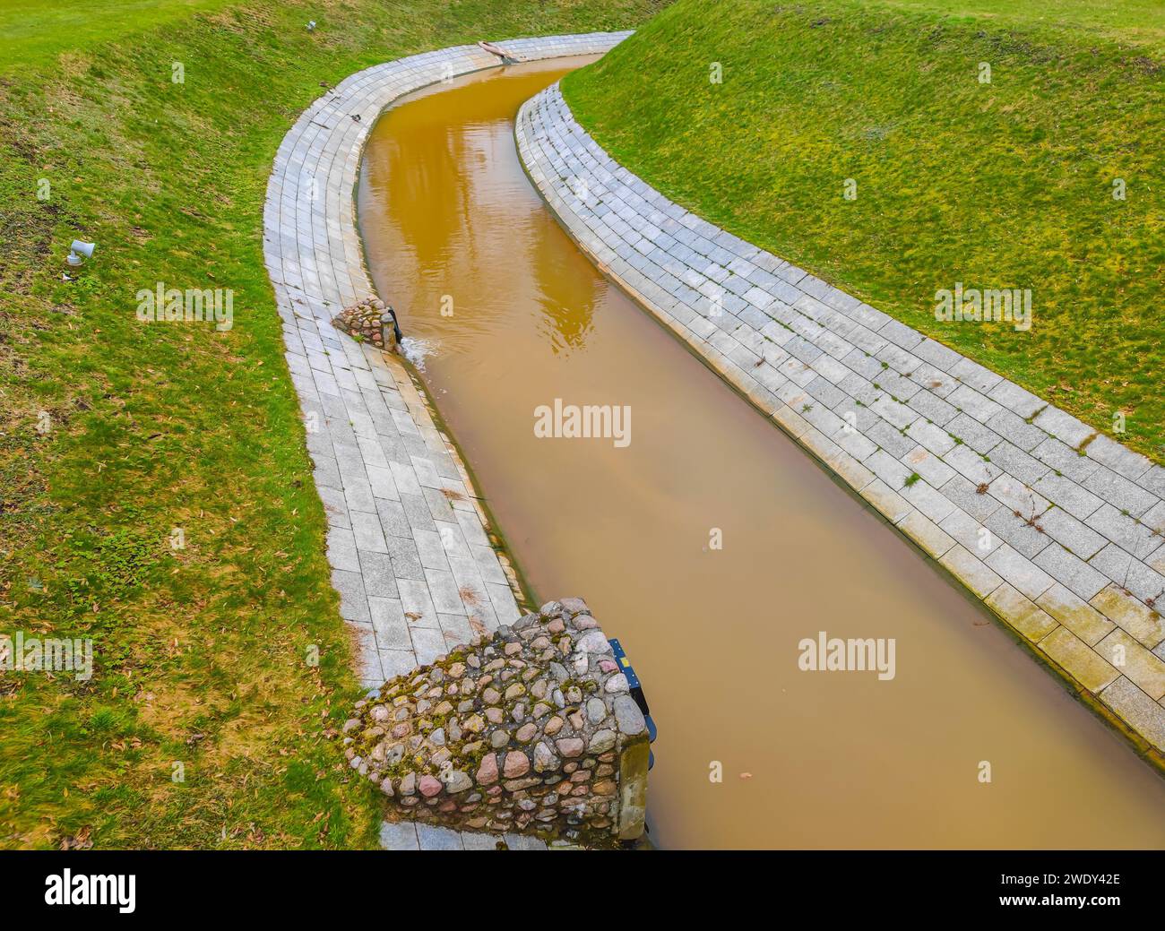 Environmental pollution of small river in city. Water pollution. Brown ...
