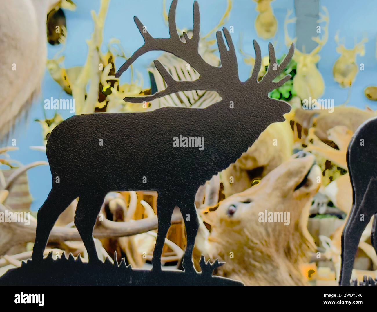 A silhouette of an elk statue with antlers is seen with abstract ...