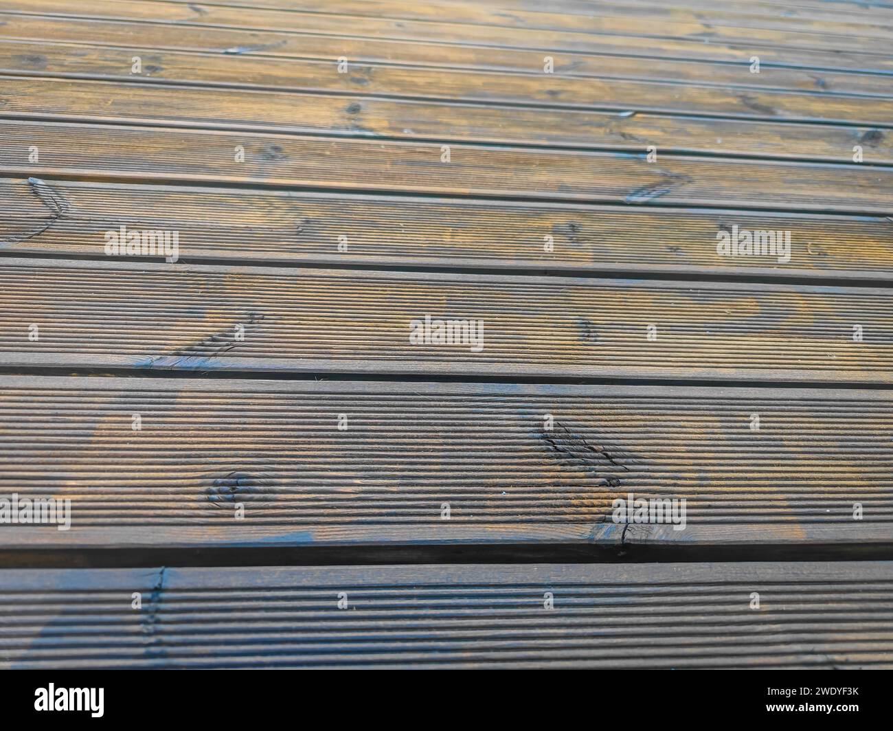 Fluted pine wood terrace freshly impregnated with dark brown oil ...