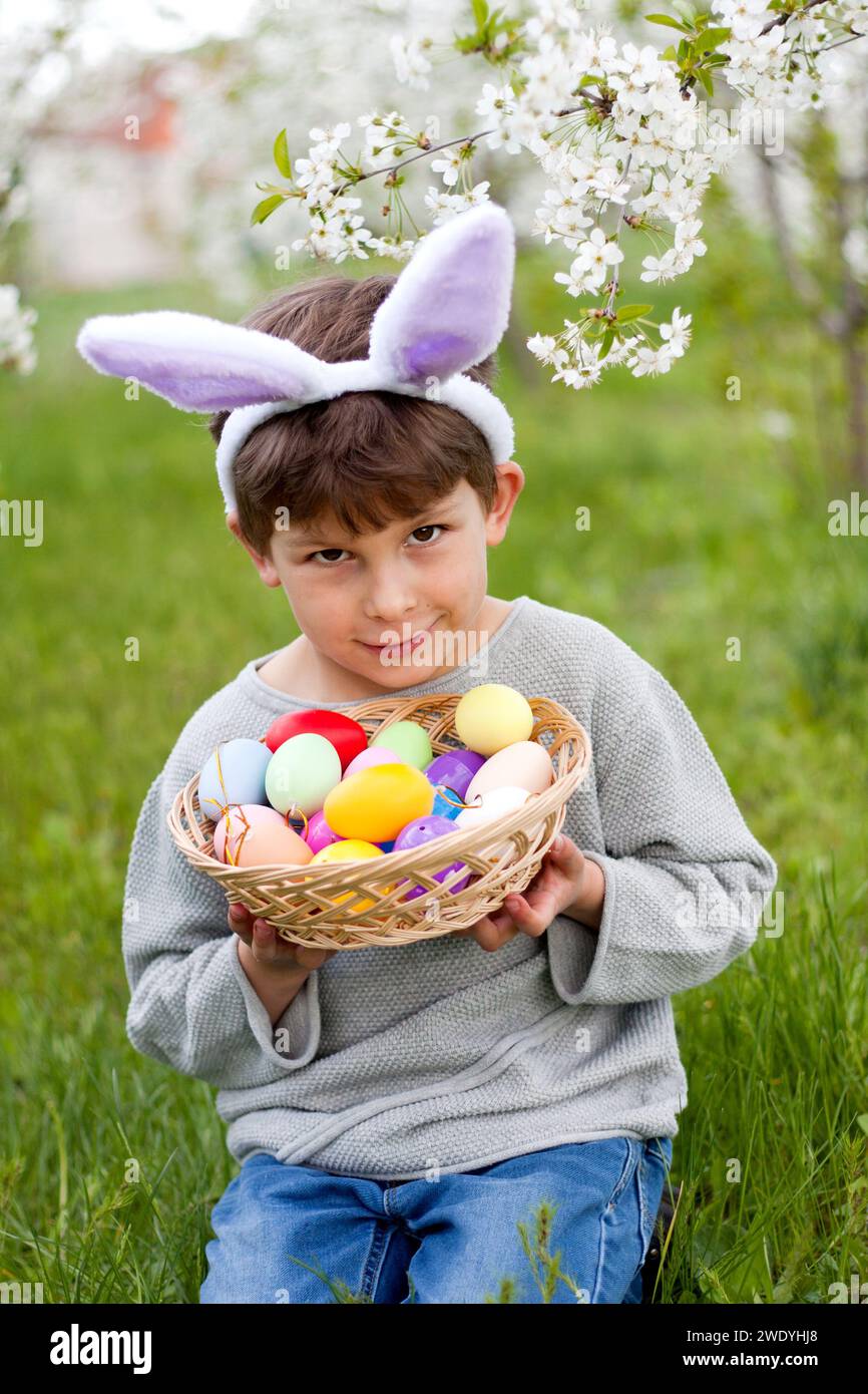 Easter egg hunt. Cute preschool boy wearing bunny ears holding full ...