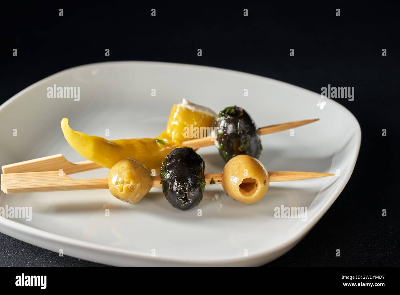 Finger food sticks olives and stuffed pepperoni on white plate Stock ...