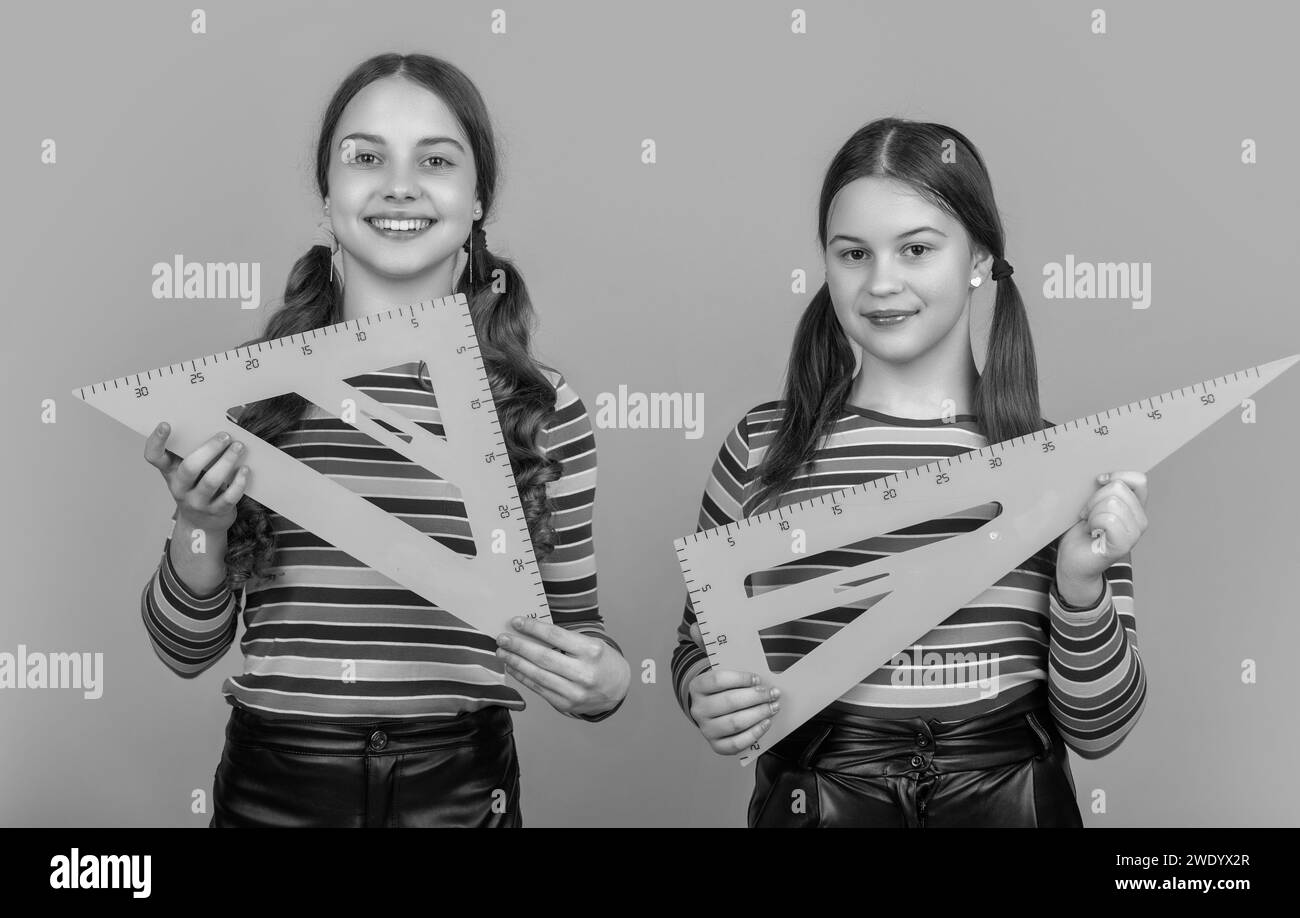 happy school children hold math tool of triangle Stock Photo - Alamy