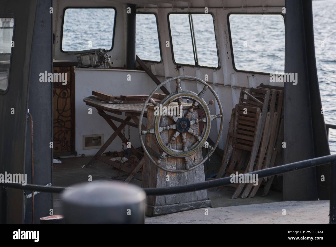 A wooden wheelhouse and wheel. Open cockpit on a boat under restoration ...