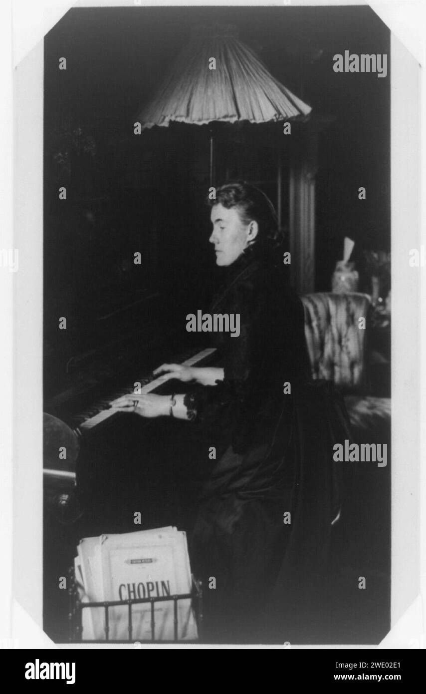 Aileen Bell, full-length portrait, facing left, playing a piano Stock ...