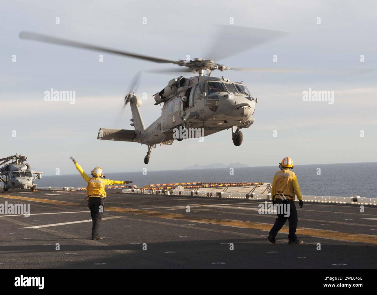 Aircraft handler signalling to pilot of HSC-23 MH-60S Sea Hawk on ...