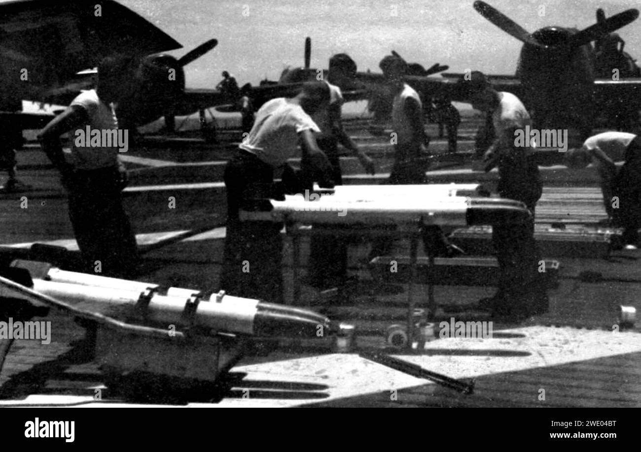 Aircraft rockets are assembled on the flight deck of USS Tripoli (CVE ...