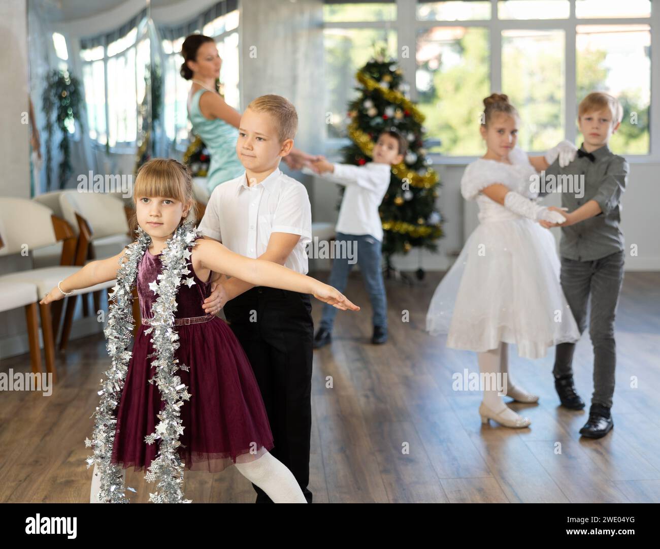 Little children practicing waltz dance in school-hall decorated with ...
