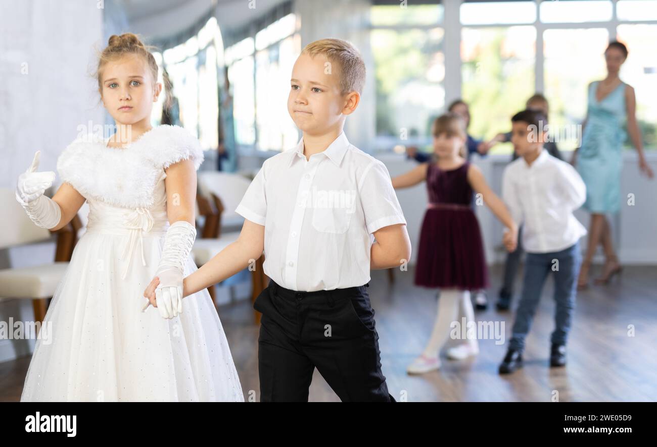 Preteen children practicing ballroom dances in pairs during dancing ...
