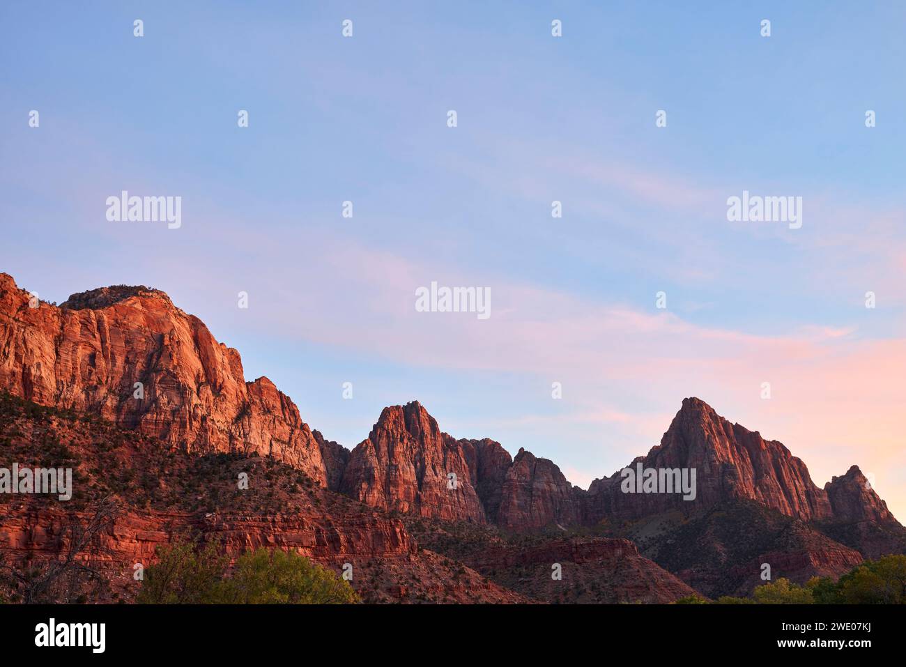 Mountain peaks painted red by the setting sun. The far right peak is ...