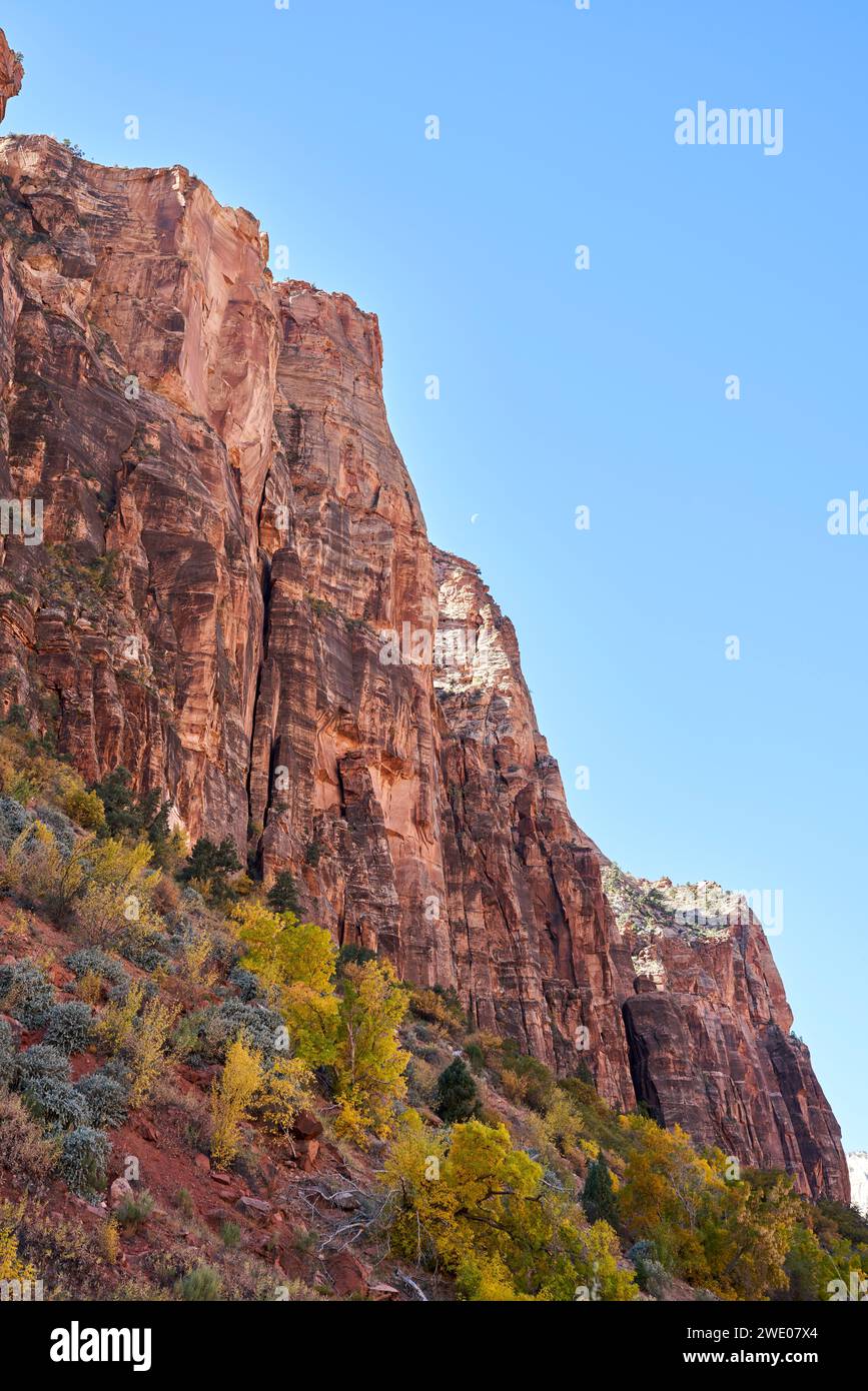 The steep mountain cliffs of zion national park. Blue sky is overhead ...