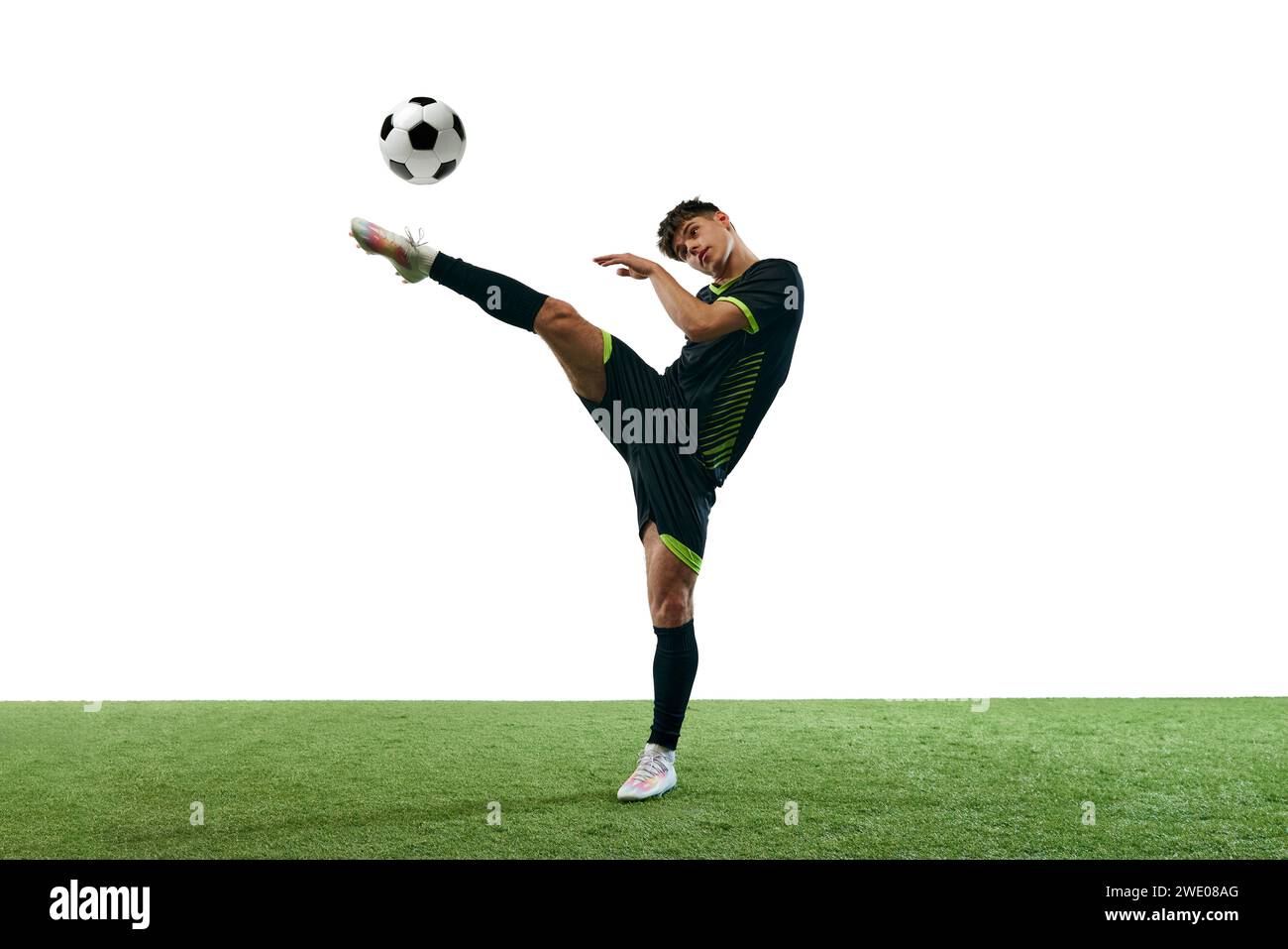Champion. Young guy, soccer player in black uniform training, hitting ...