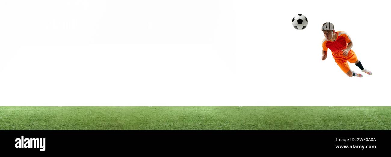 Young man, football player in orange hitting ball in a jump with head ...