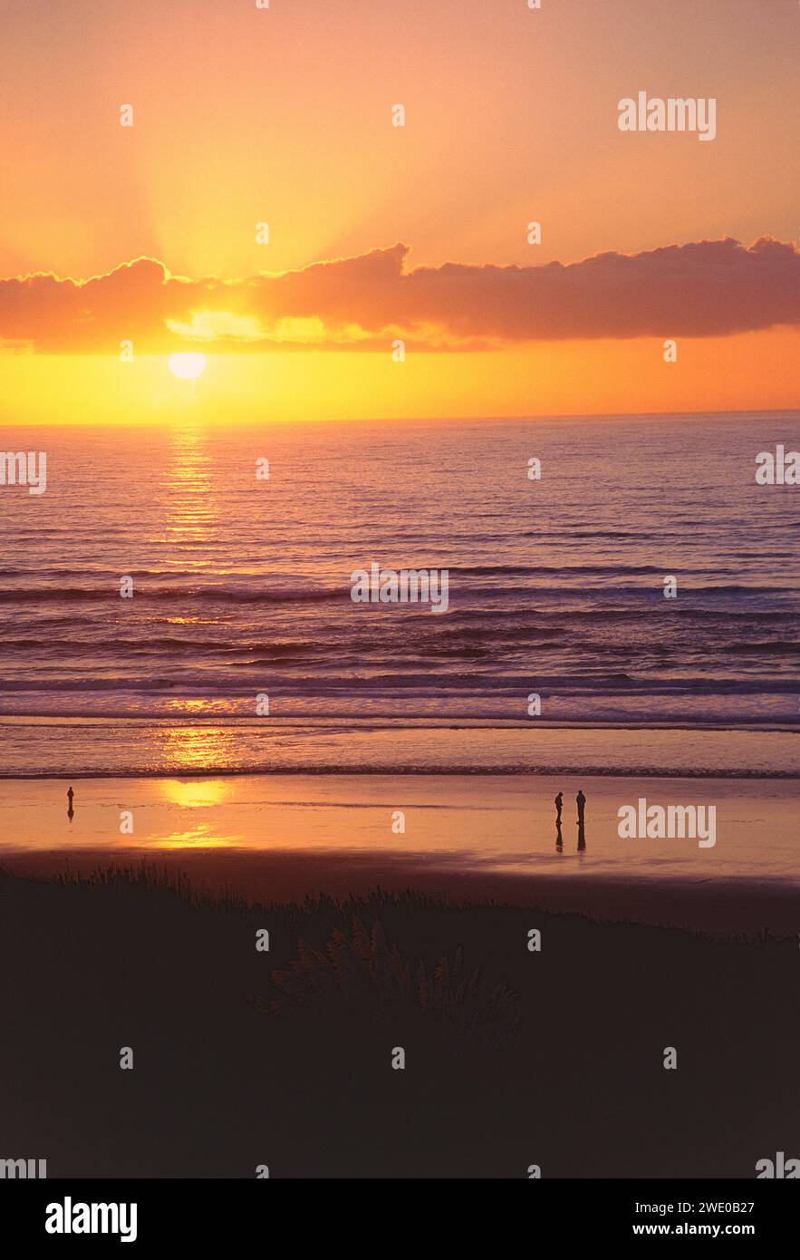 Visitors walk beach at dramatic sunset; Pacific Ocean; Newport; Oregon ...