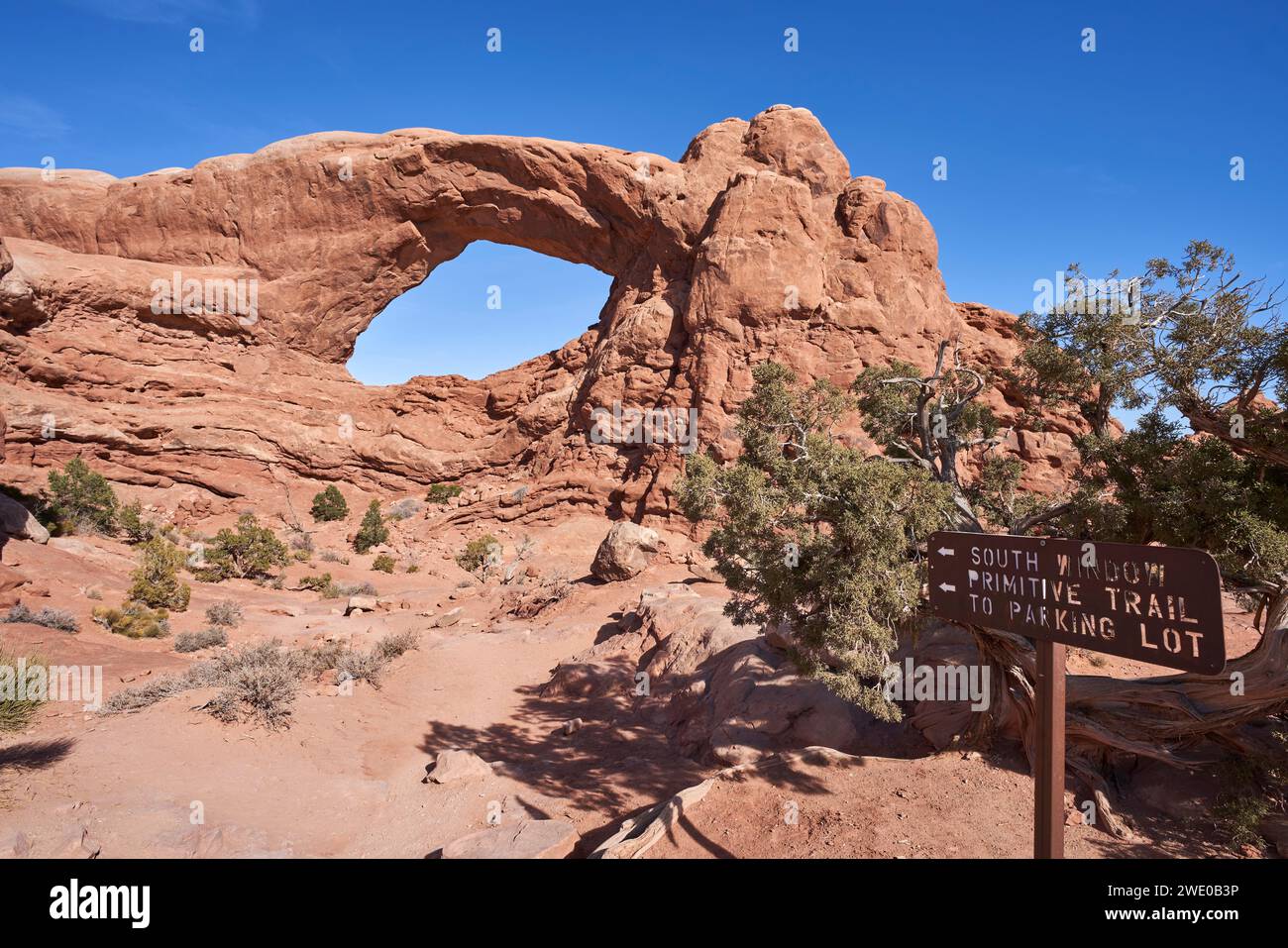 A trail marker sign points to the south window arch of Arches National ...