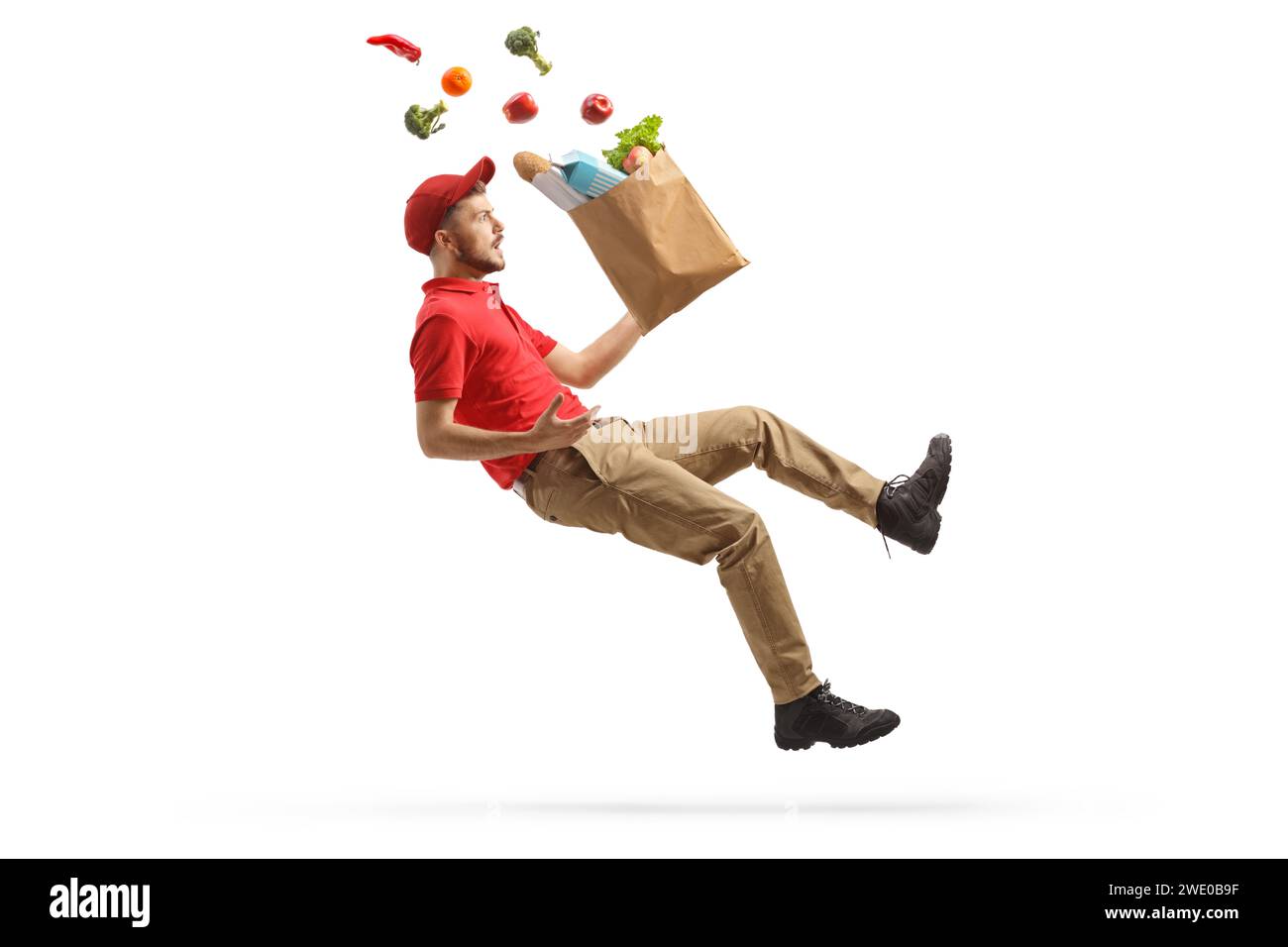 Delivery man with a grocery bag tumbling and falling isolated on white ...