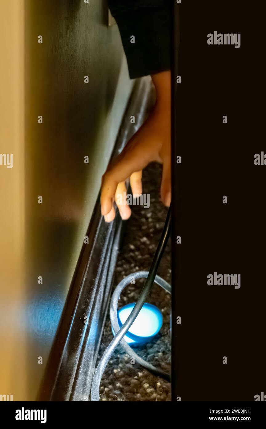 Reaching for an object that fell behind a desk Stock Photo - Alamy