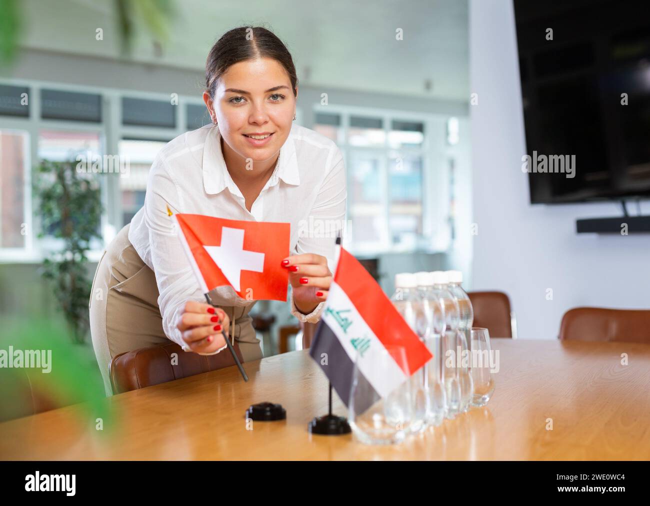 Female secretary places flags of the Iraq and Switzerland flag on the ...